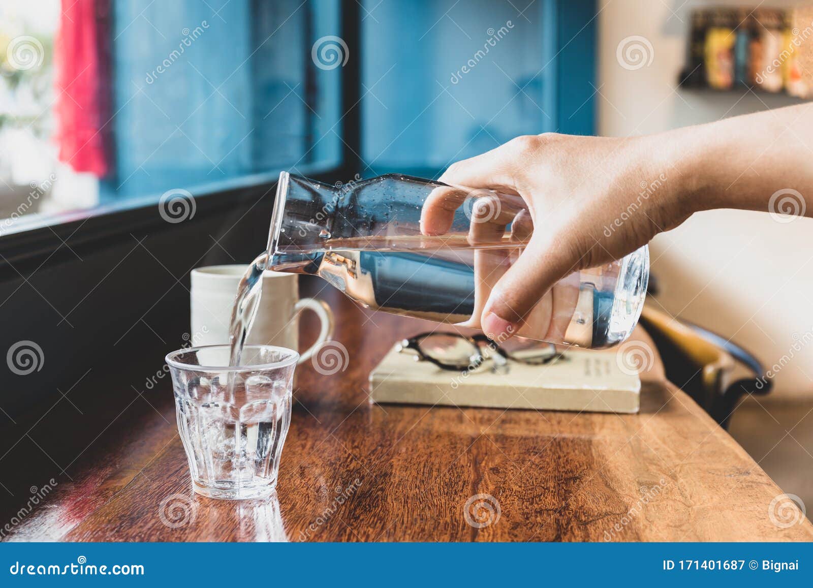 Man`s Hand Pouring Fresh Water from Pitcher into a Glass in Cafe. Stock ...