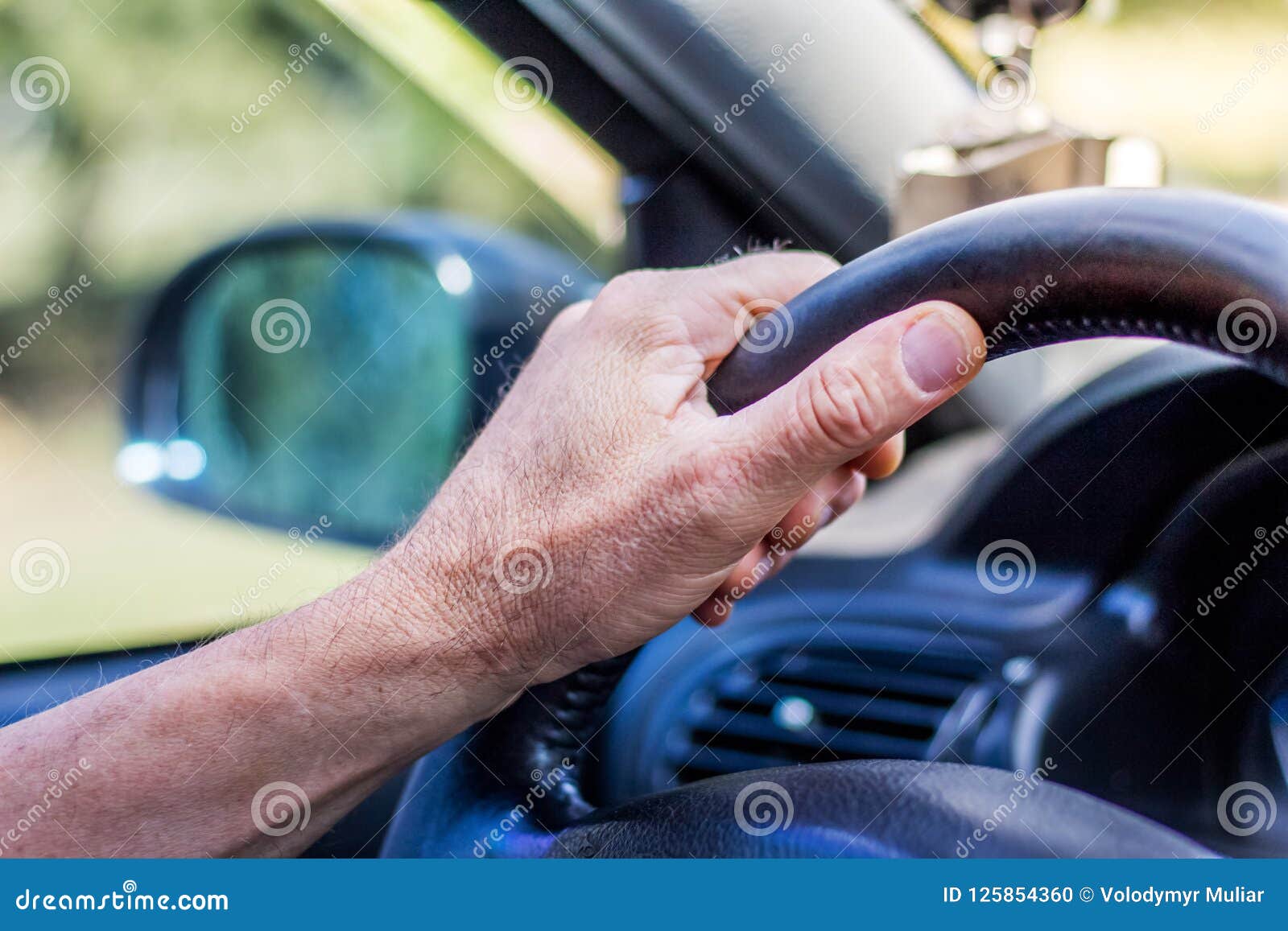 Man`s Hand on Steering Wheel of a Car. Driving on the Road_ Stock Photo ...