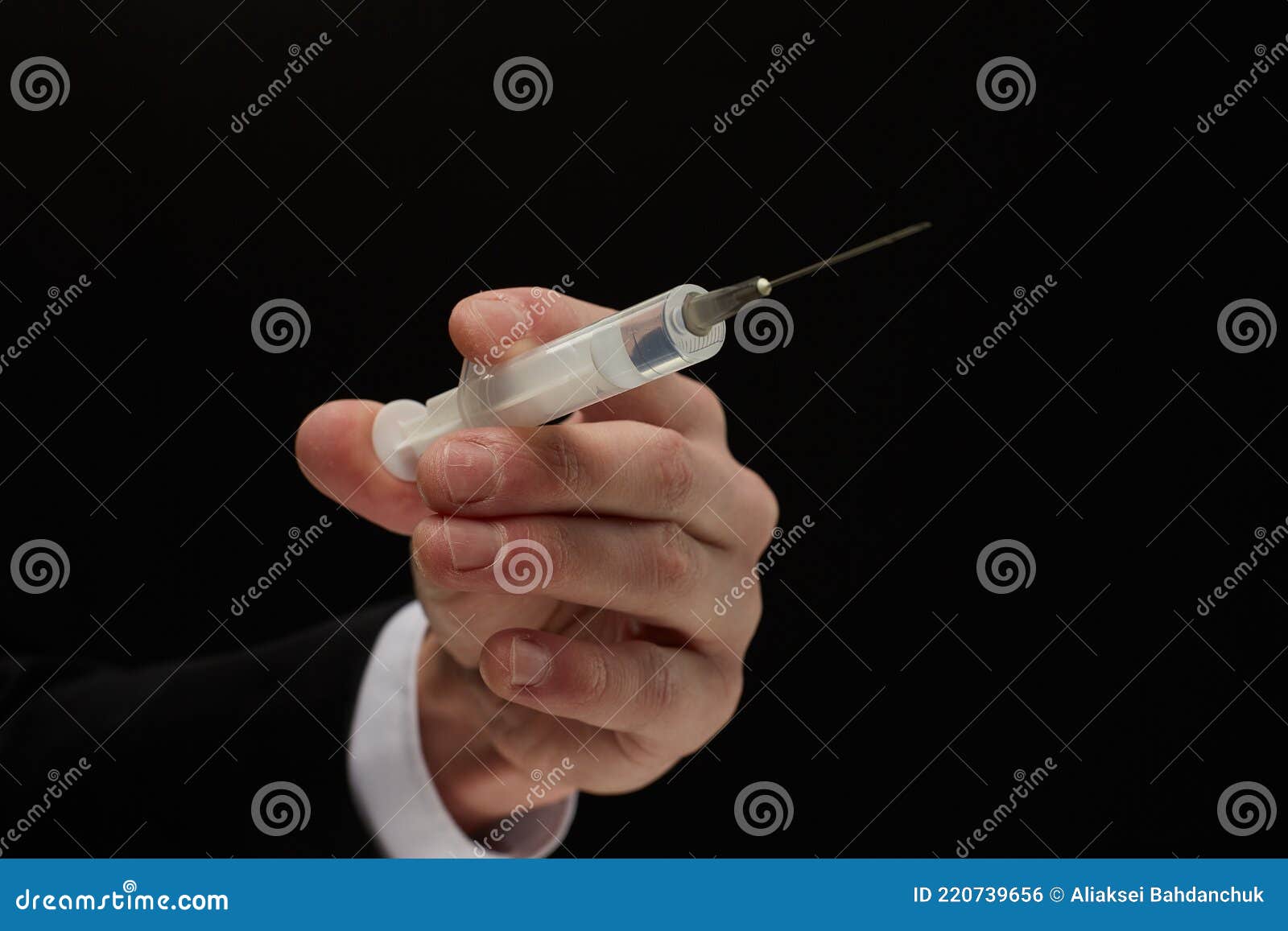 A Man& X27;s Hand with a Syringe on Black Background Stock Photo ...