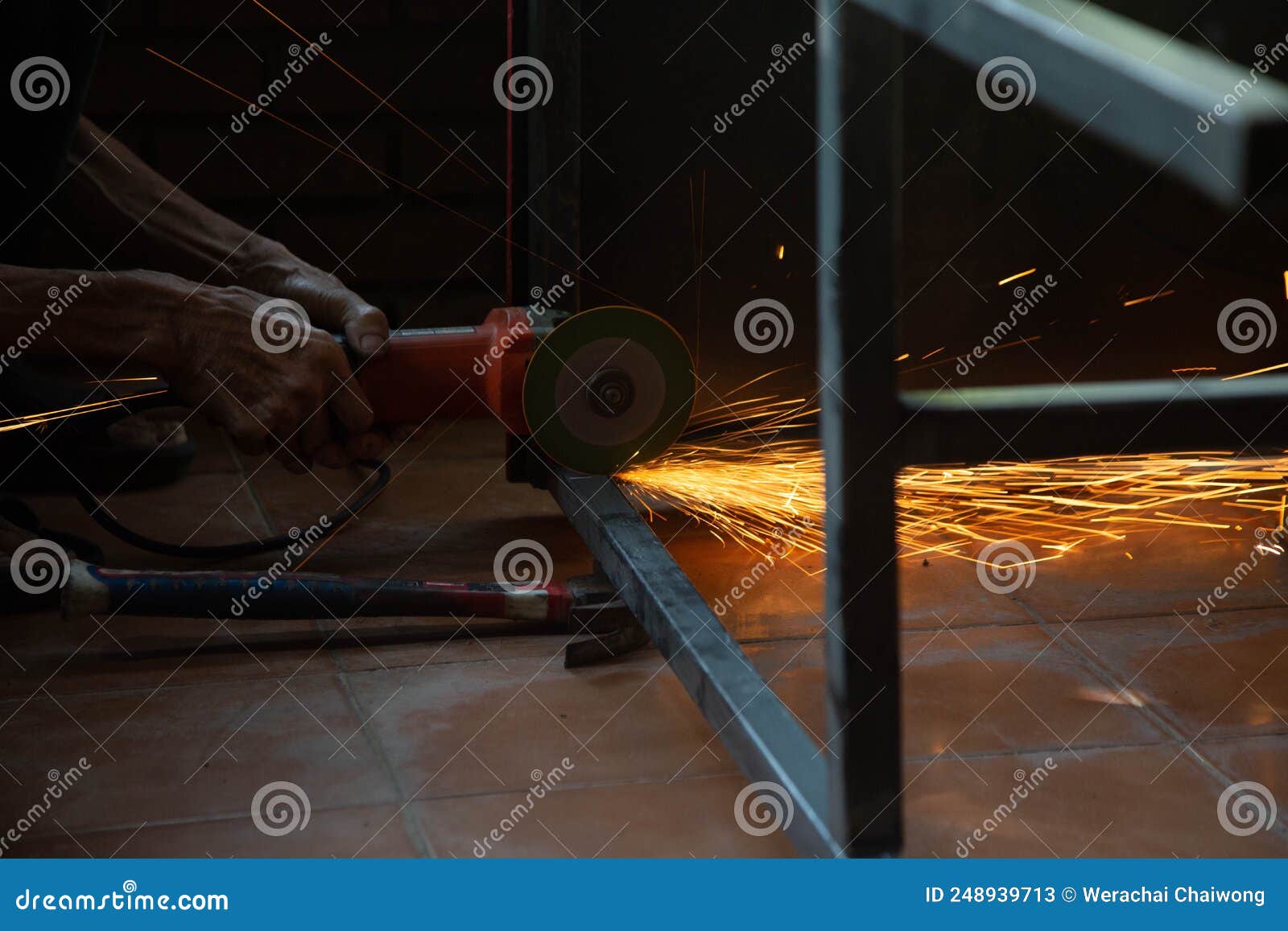 A Man`s Hand is Using a Steel Cutter To Make a Spark Table Structure ...