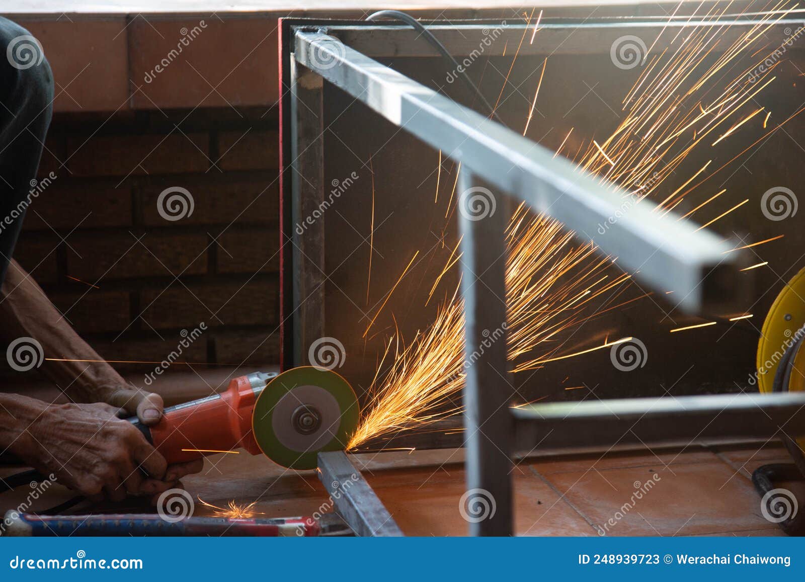 A Man`s Hand is Using a Steel Cutter To Make a Spark Table Structure ...