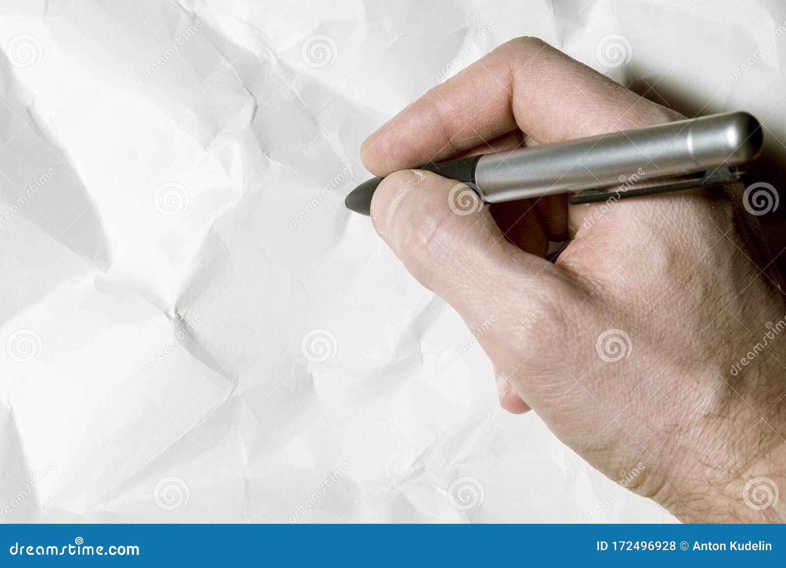 A Man`s Hand Writes with a Pen on a Sheet of Crumpled Paper Stock Photo ...
