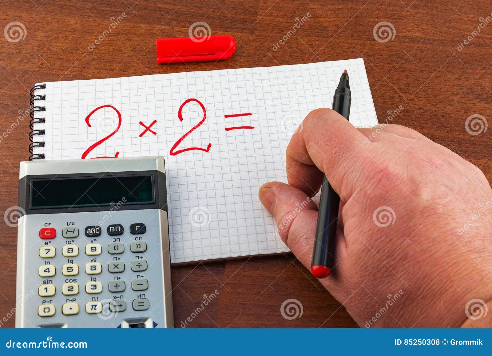 Man`s Hand Writing Equation on the Notebook Sheet in a Cage Stock Photo ...