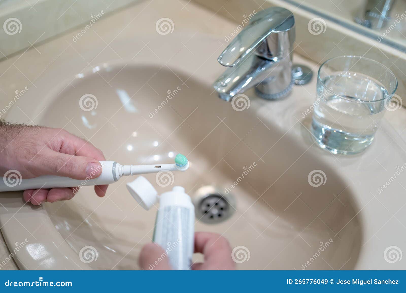 Man& X27;s Hands Pouring Toothpaste into an Electric Toothbrush in the ...