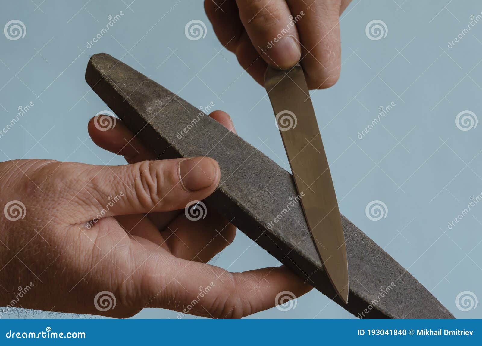 Man`s Hands are Sharpening a Small Knife on a Grindstone Stock Photo ...
