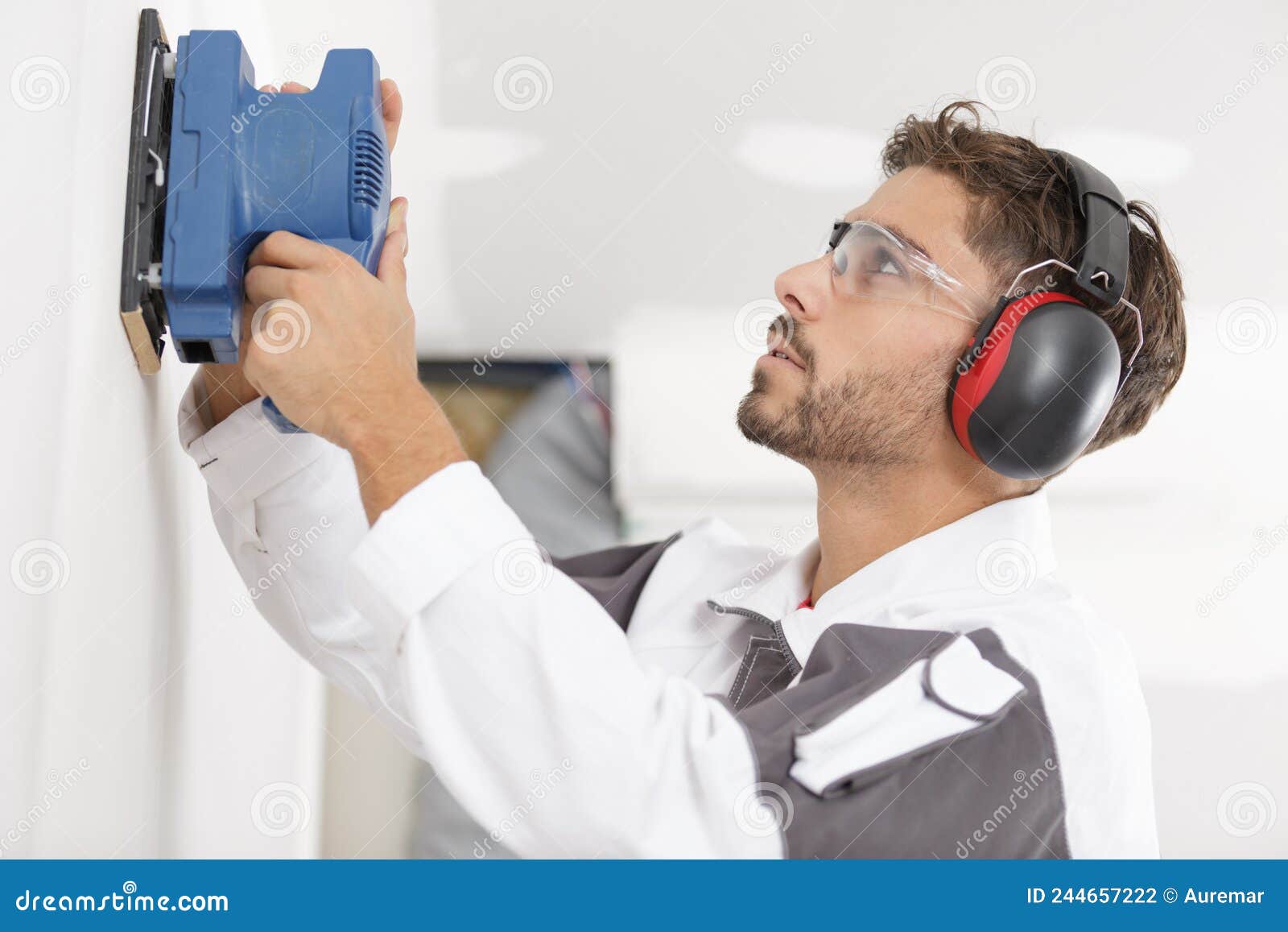 Man sanding wall stock photo. Image of professional - 244657222
