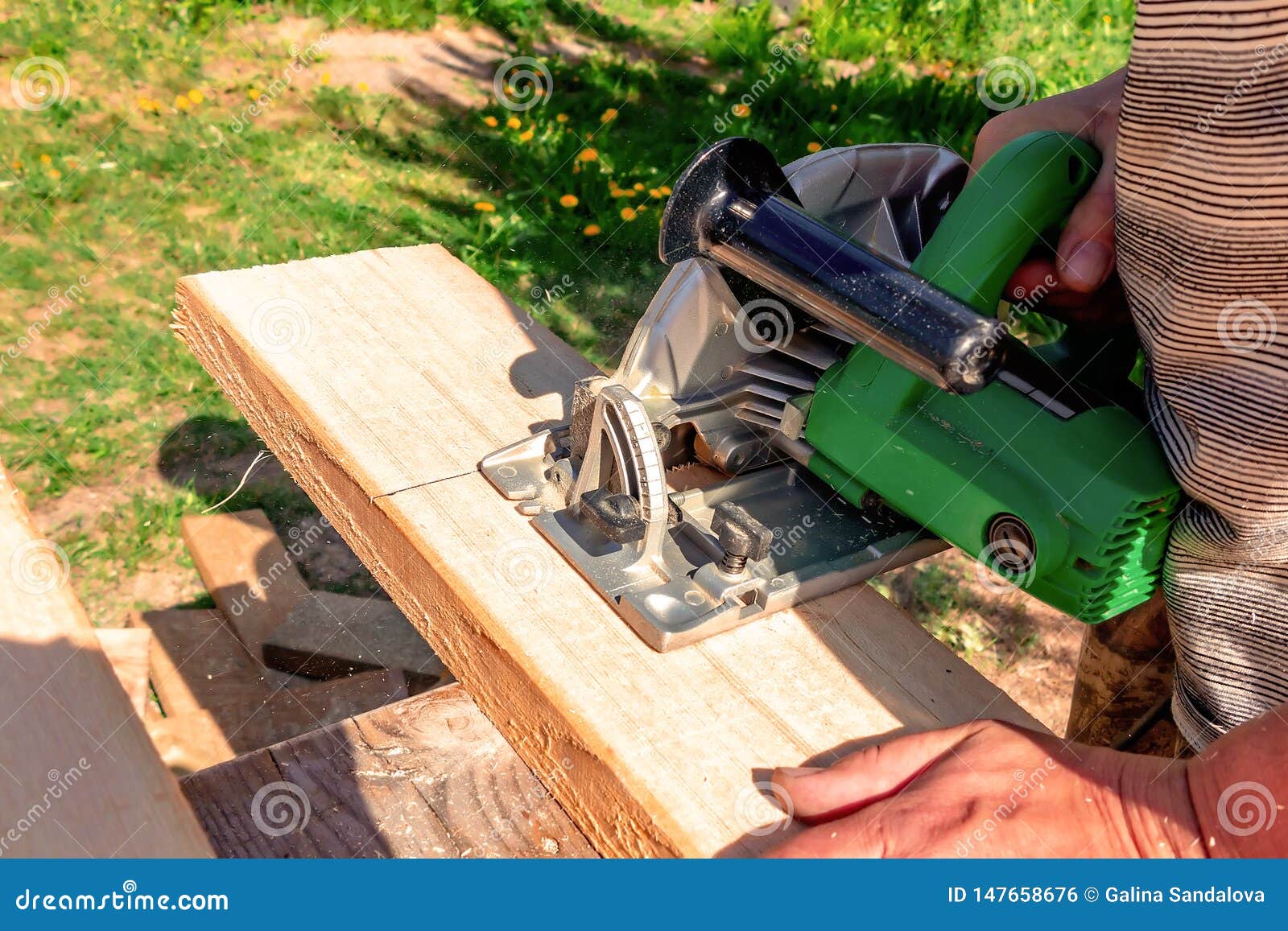 A Man is Sawing a Board with a Circular Saw in the Open Air Stock Photo ...