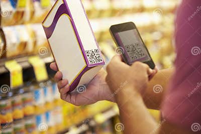 Man Scanning Voucher Code in Supermarket with Mobile Phone Stock Photo ...