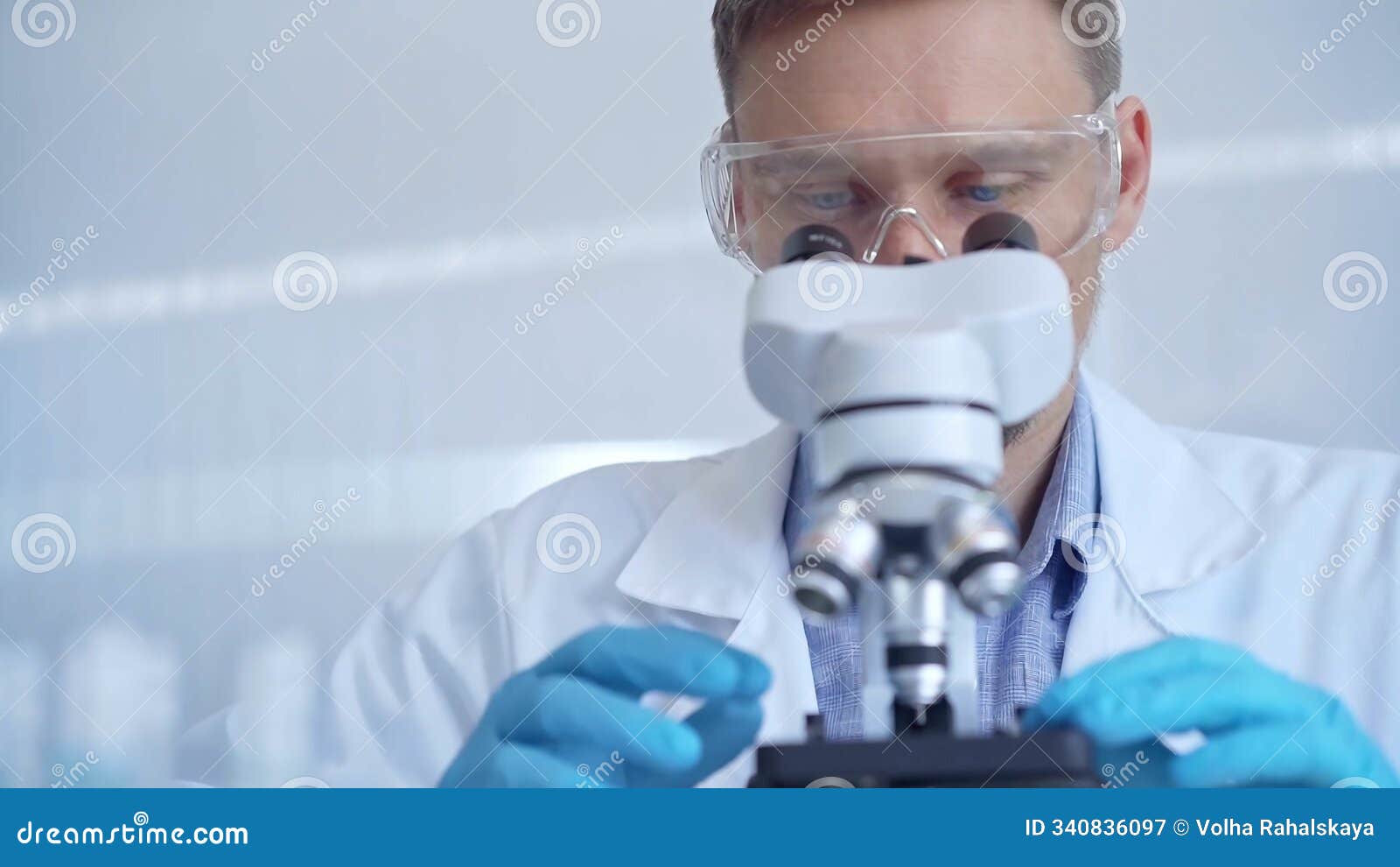 Man Scientist with Protective Glasses and Gloves is Using Microscope in ...