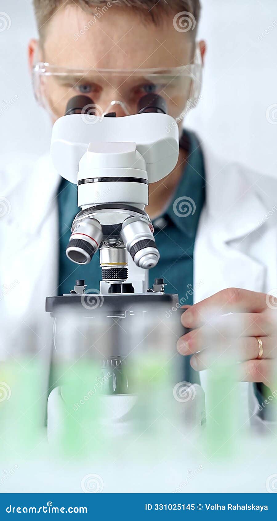 Man Scientist with Protective Glasses Using Microscope in Laboratory ...