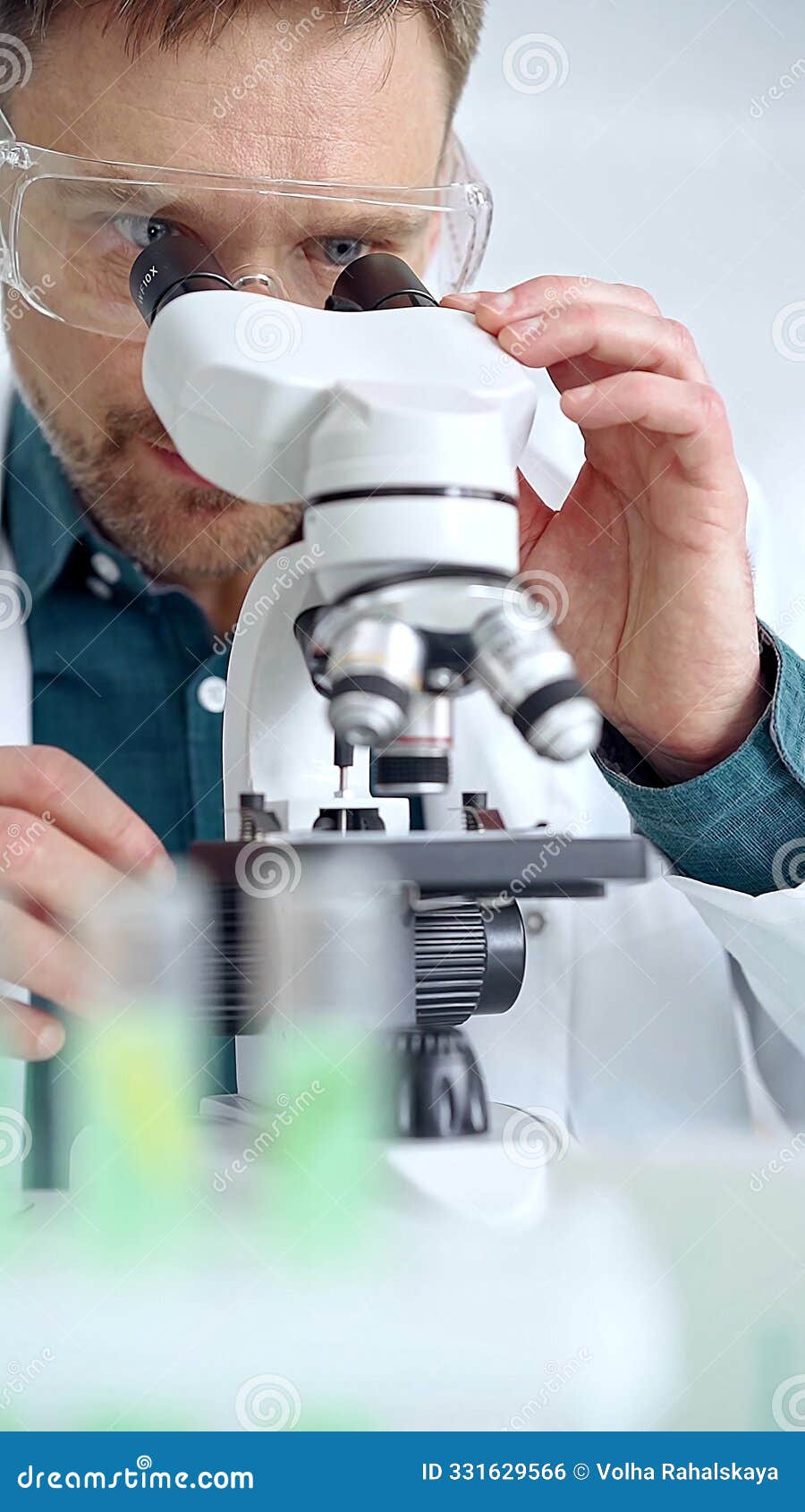 Man Scientist with Protective Glasses Using Microscope in Laboratory ...