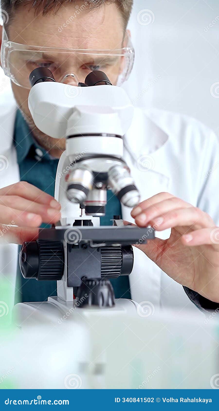Man Scientist with Protective Glasses Using Microscope in Laboratory ...