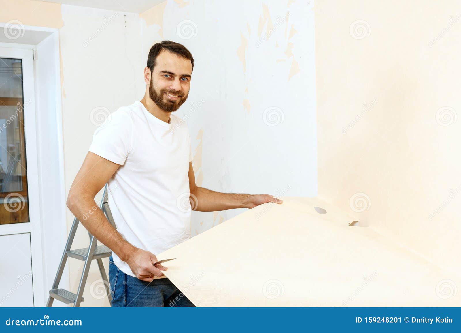 Man in with a Scraper in the Process of Removing Old Wallpaper. Stock ...