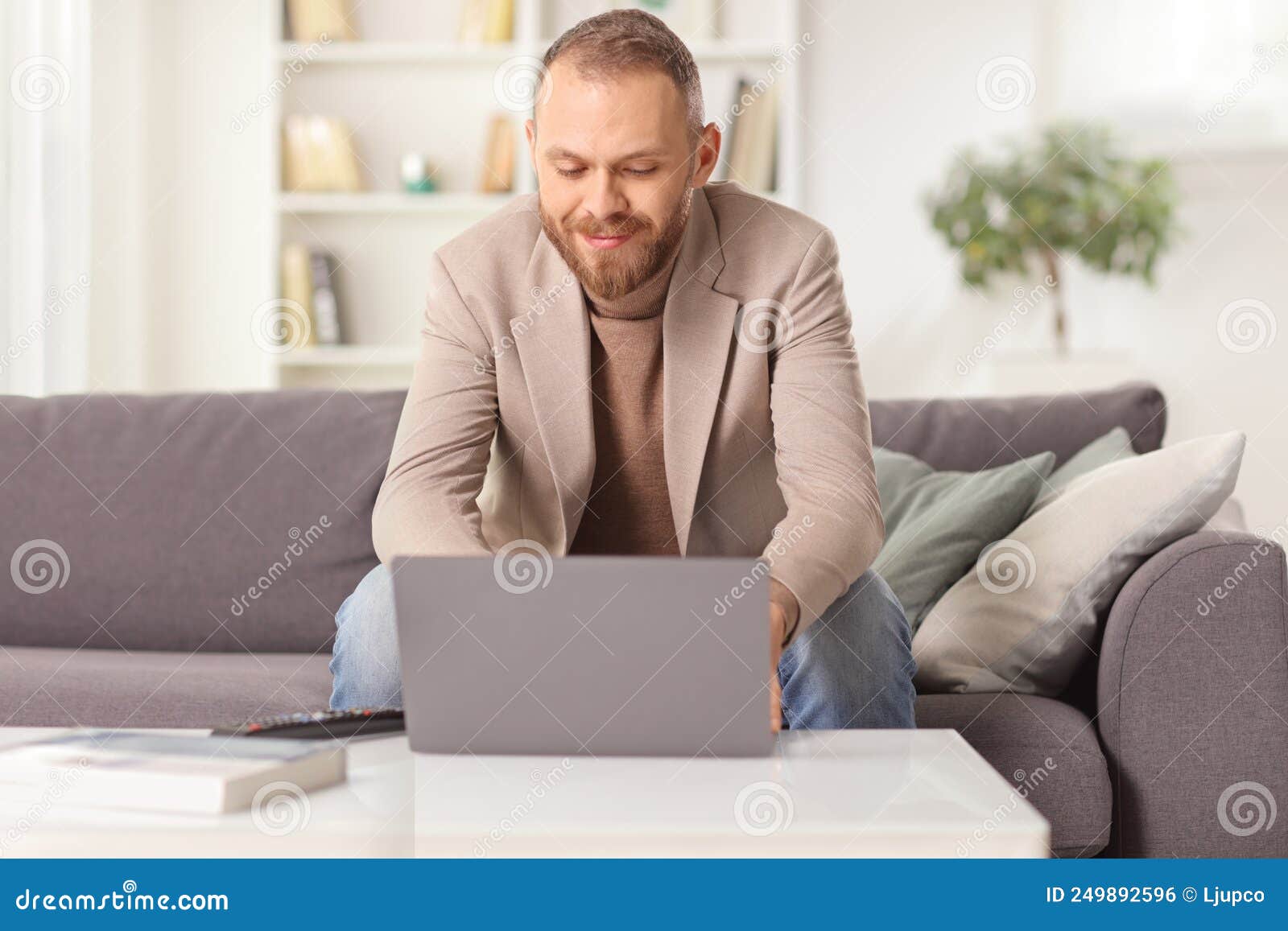 Man Seated on a Sofa with a Laptop Computer on the Table Stock Photo ...