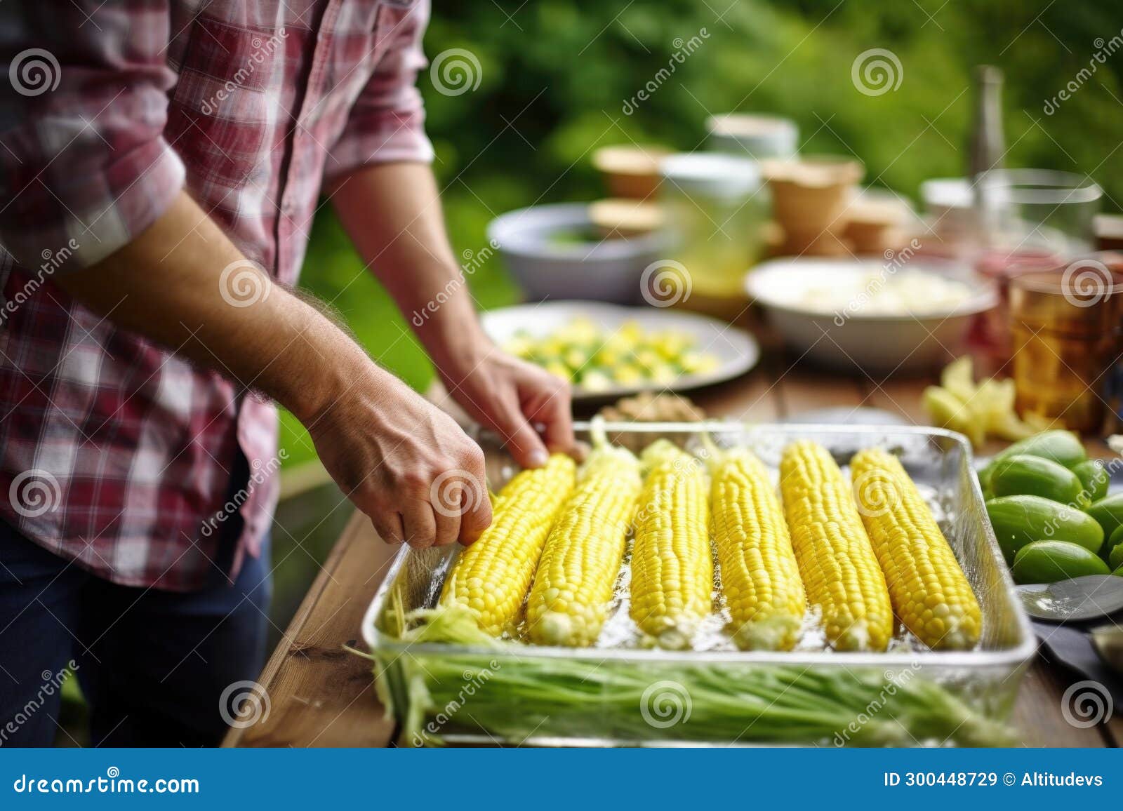 Man Setting Down Tray of Butter Glazed Sweet Corn at a Potluck Stock ...