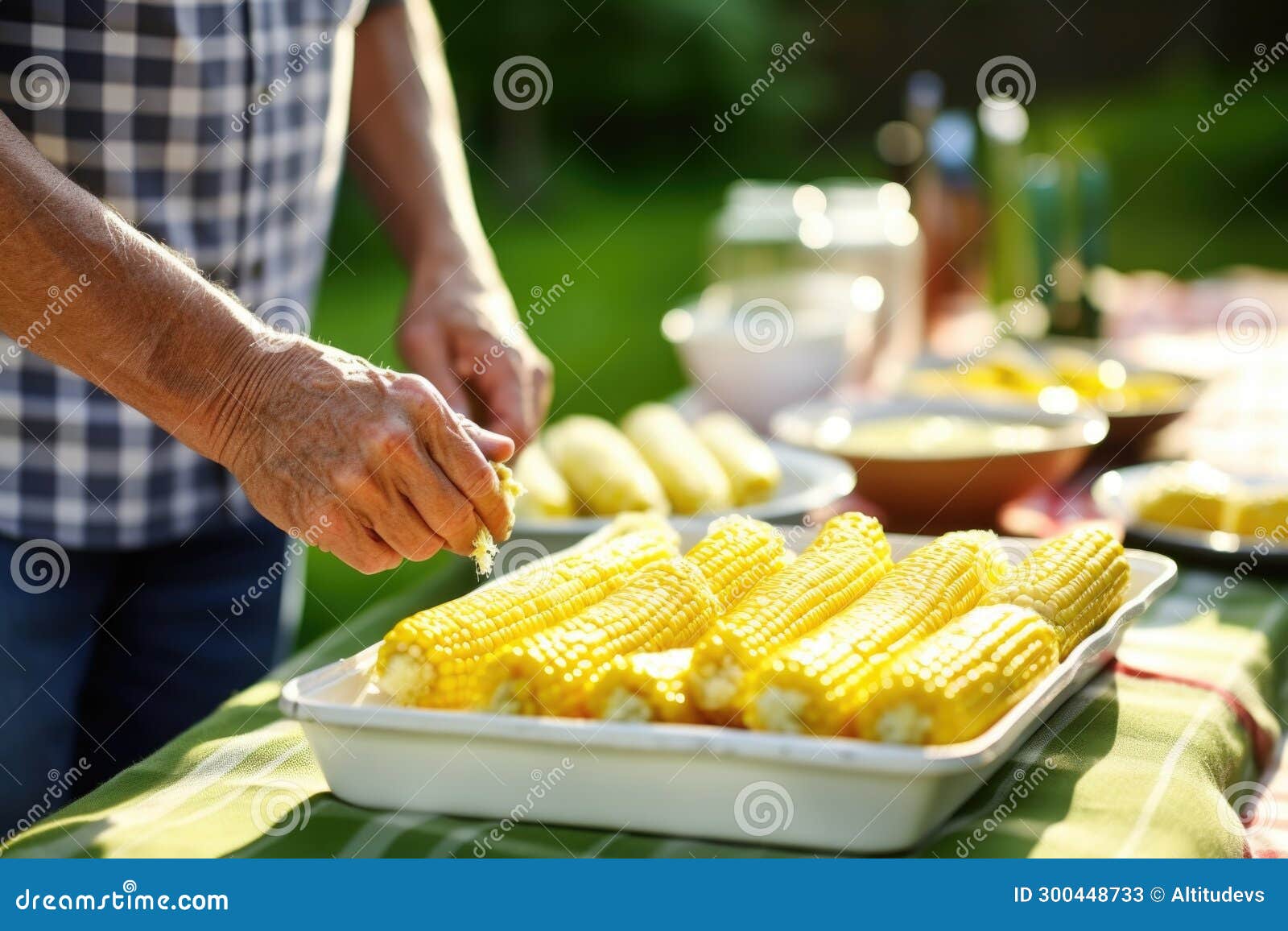 Man Setting Down Tray of Butter Glazed Sweet Corn at a Potluck Stock ...