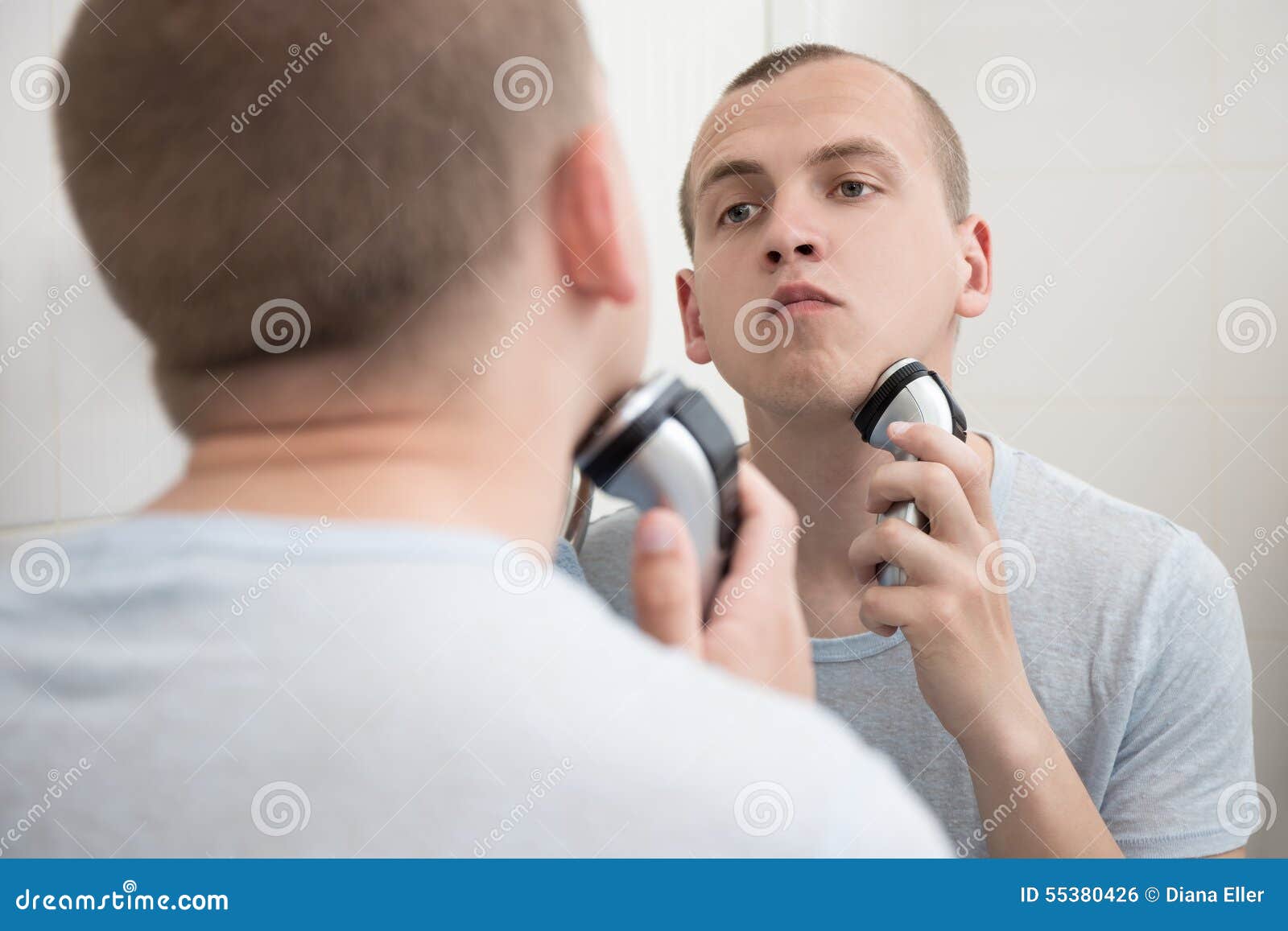 Man Shaving with Electric Razor in Bathroom Stock Photo - Image of ...