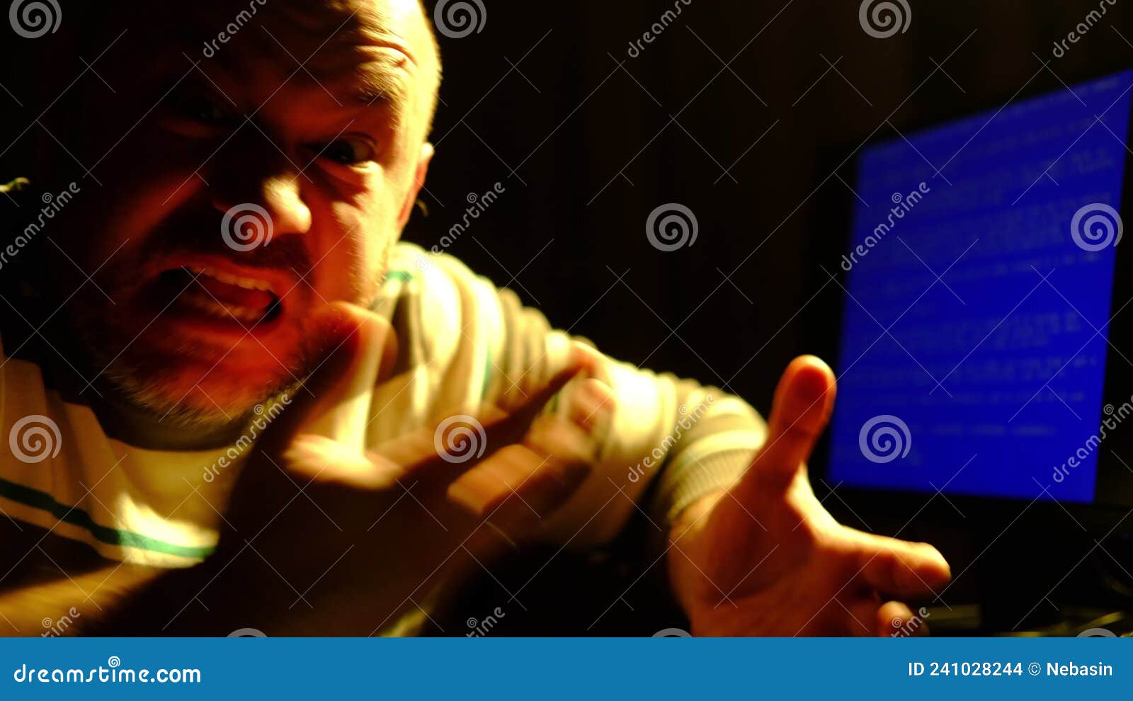 A Man is Shocked in Front of a Blue Computer Screen in the Dark. Stress ...