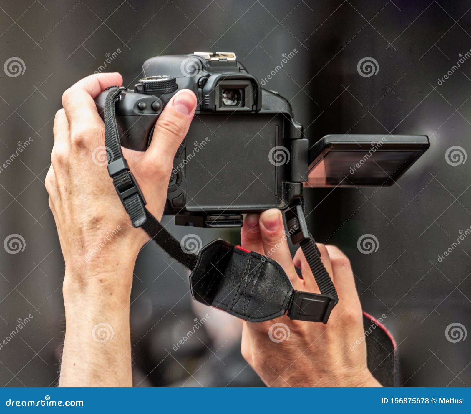 A Man Shoots Video Over a Crowd Holding a DSLR Camera Stock Photo ...