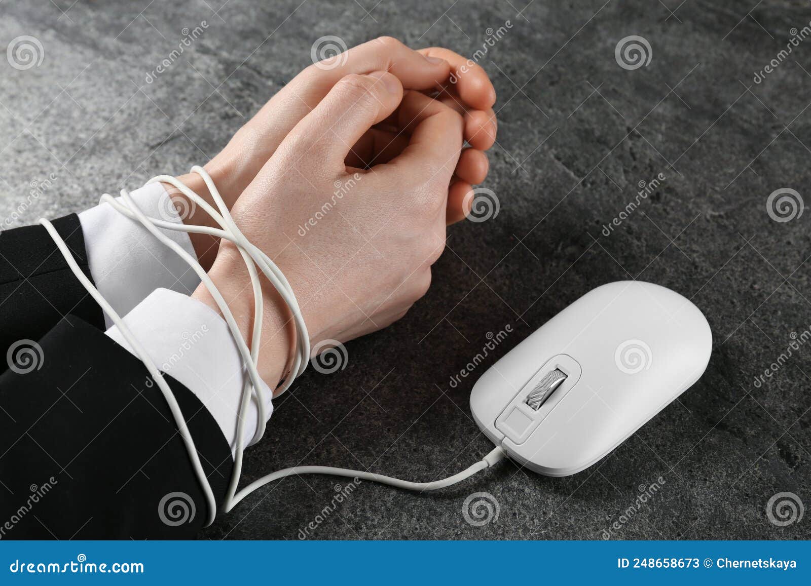 Man Showing Hands Tied with Computer Mouse Cable at Grey Table, Closeup ...