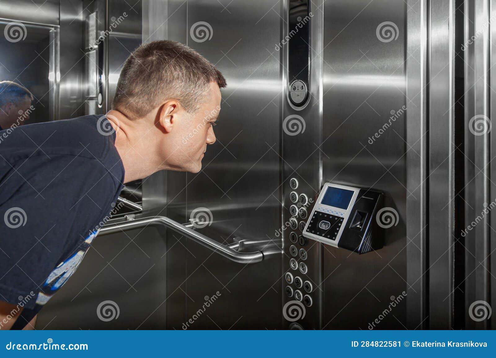 A Man Shows His Face To a Fingerprint Access Control Terminal with a Facial Recognition Function ...