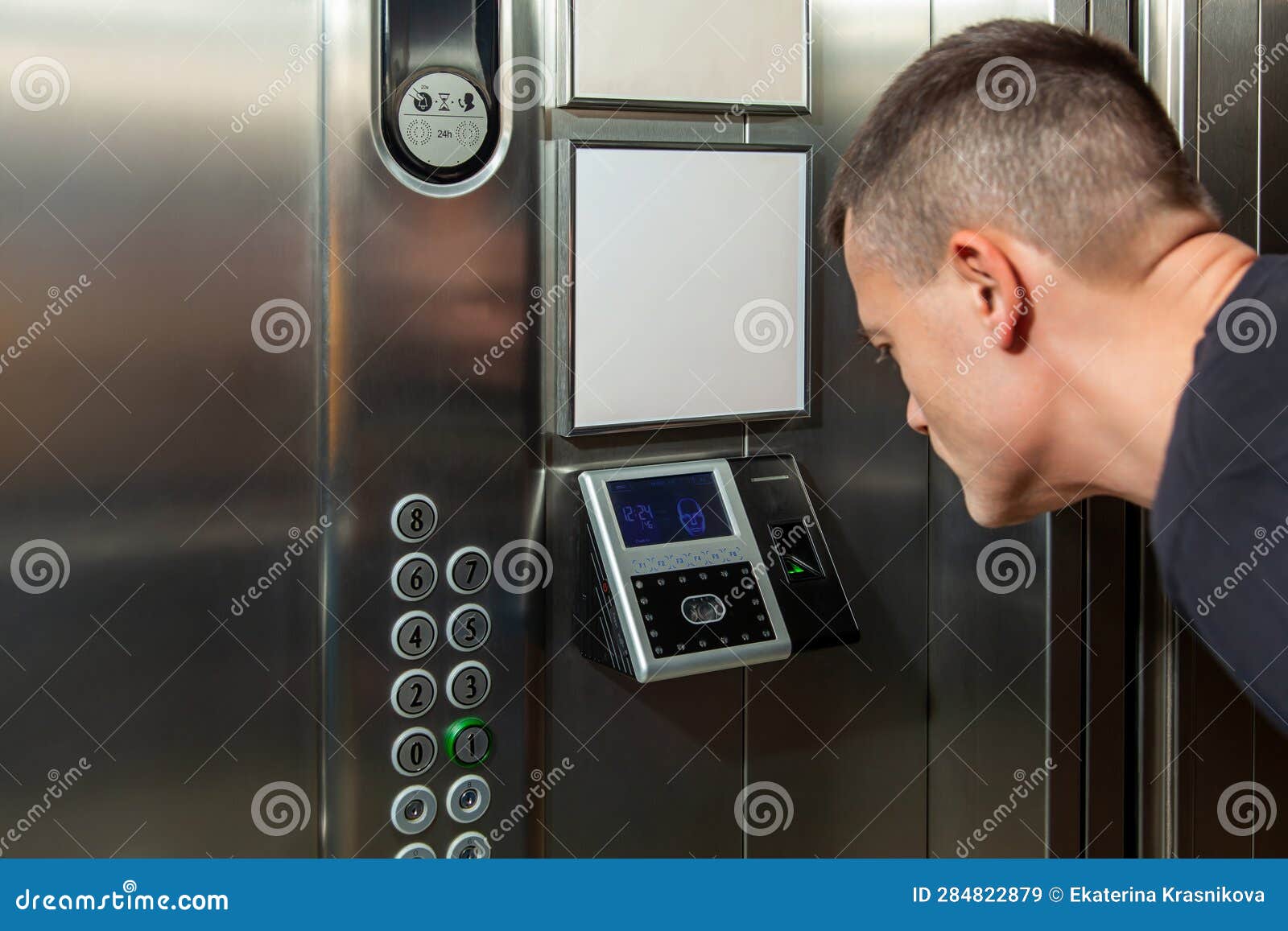 A Man Shows His Face To a Fingerprint Access Control Terminal with a Facial Recognition Function ...