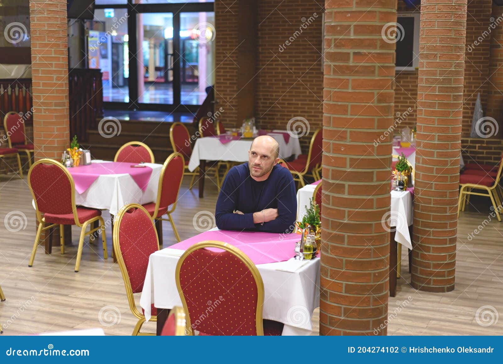 A Man Sits at an Empty Table at the Restaurant in Anticipation of the ...