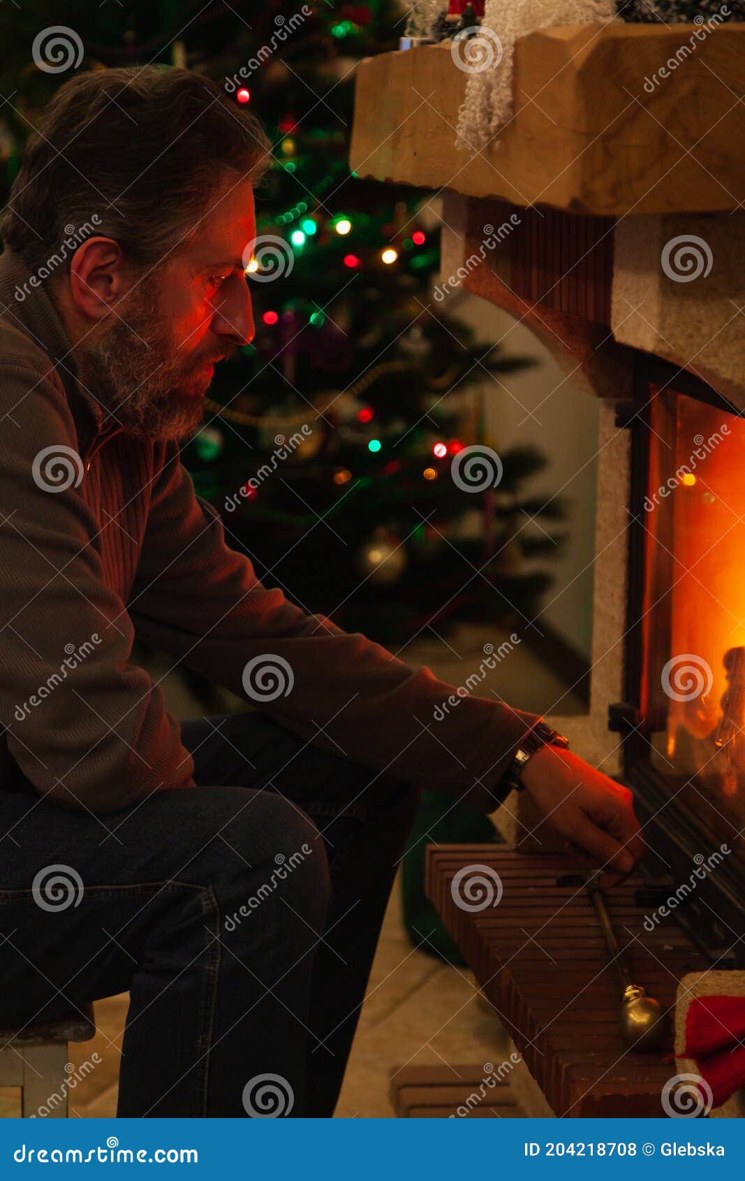 Man Sits in Front of Burning Fireplace. Behind Christmas Tree Stock ...