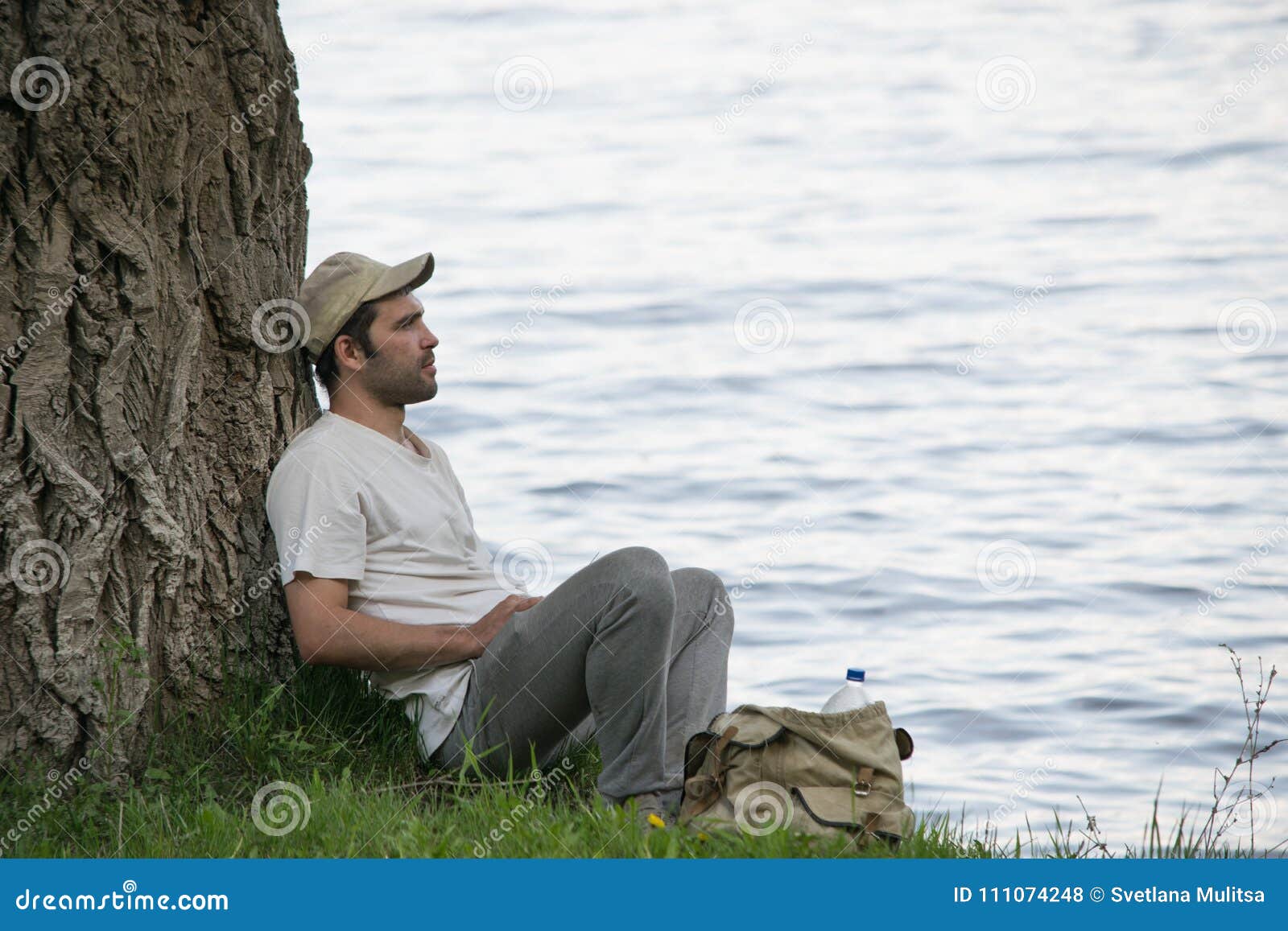 Young Man is Resting Near a Tree on the River Bank Stock Photo - Image ...