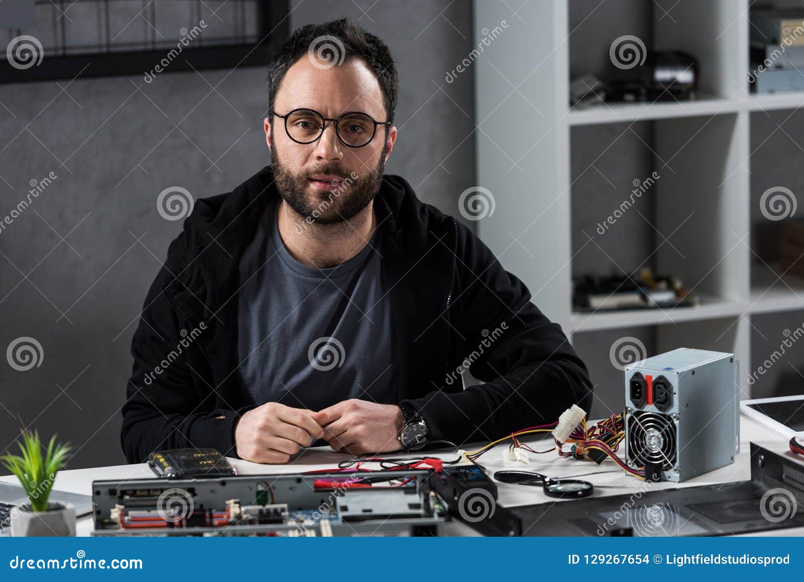 Man Sitting Against Broken Computer on Table and Looking Stock Photo ...