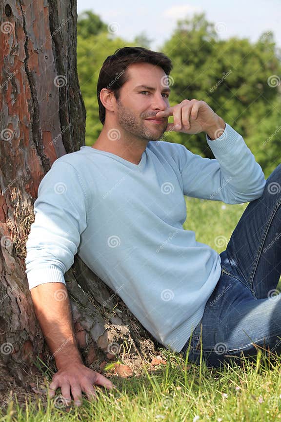Man Sitting Against a Tree. Stock Photo - Image of adult, sunny: 24017620