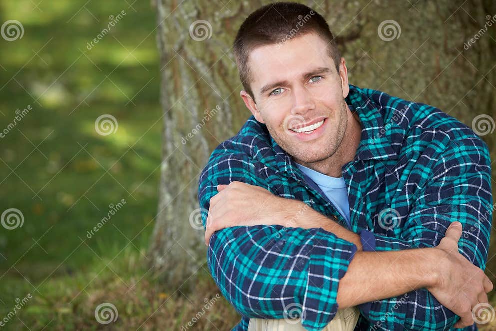 Man Sitting Against Tree Trunk Stock Photo - Image of camera, holiday ...