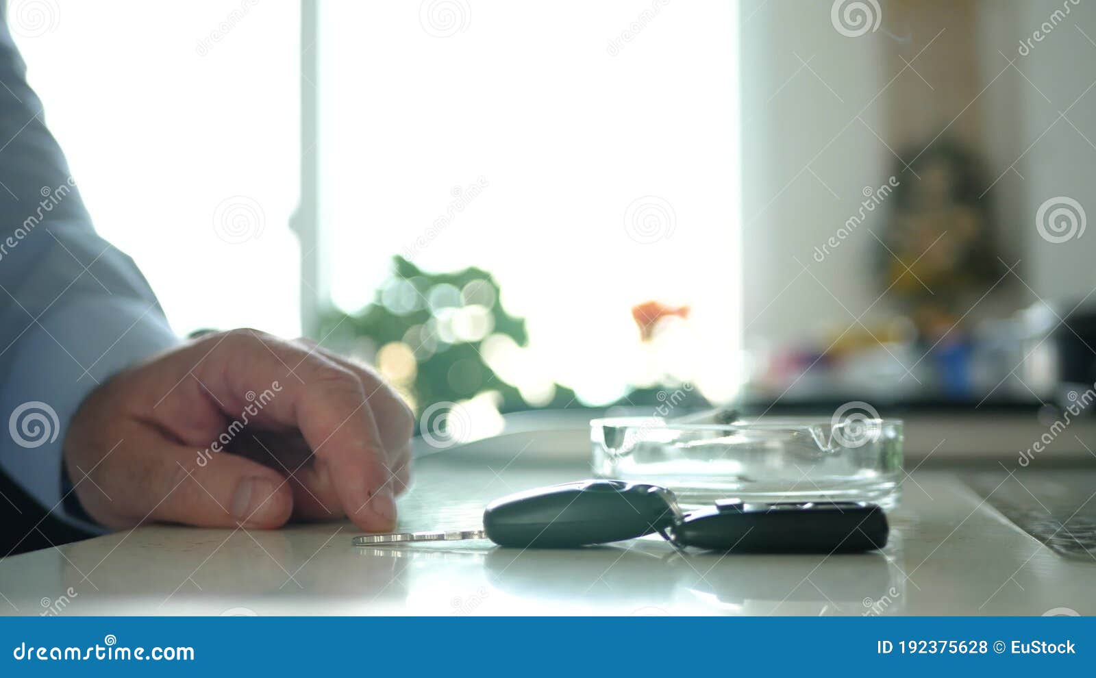 A Man Sitting at the Bar with Car Keys on the Table Smoking a Cigarette ...