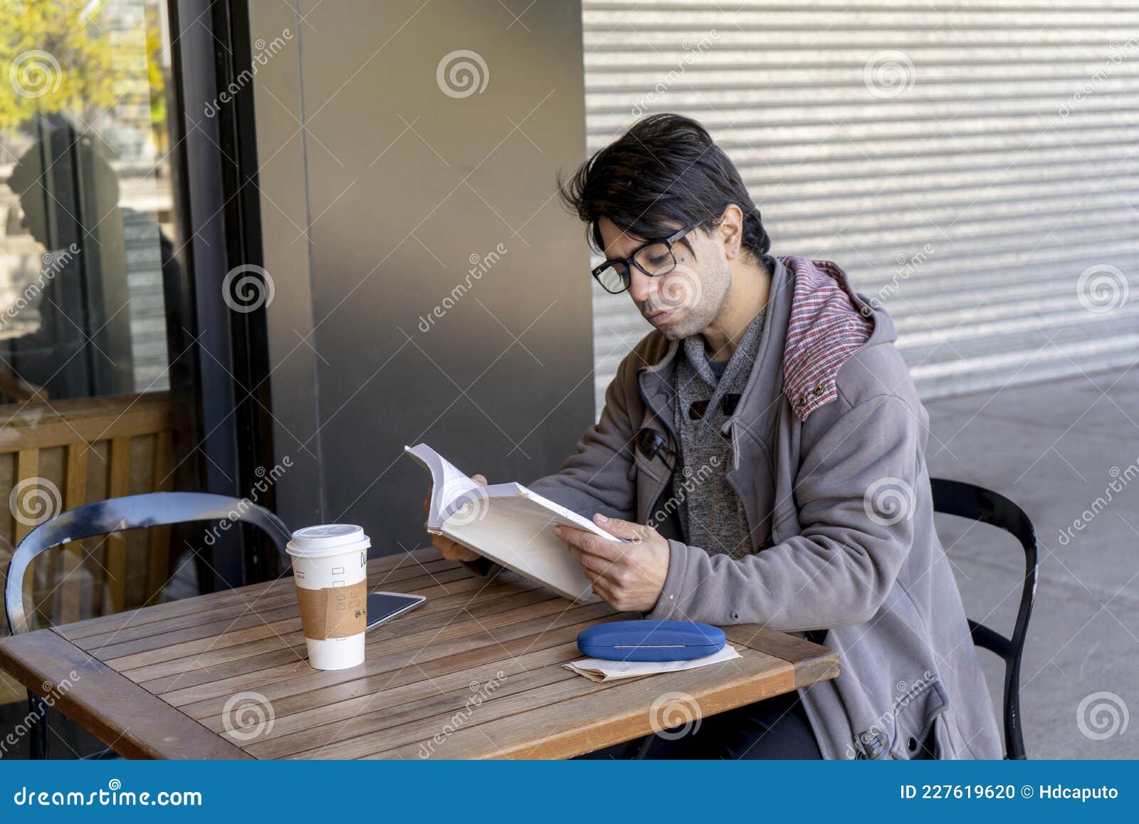 Man Sitting in a Bar Drinking Coffee while Reading a Book Stock Photo ...