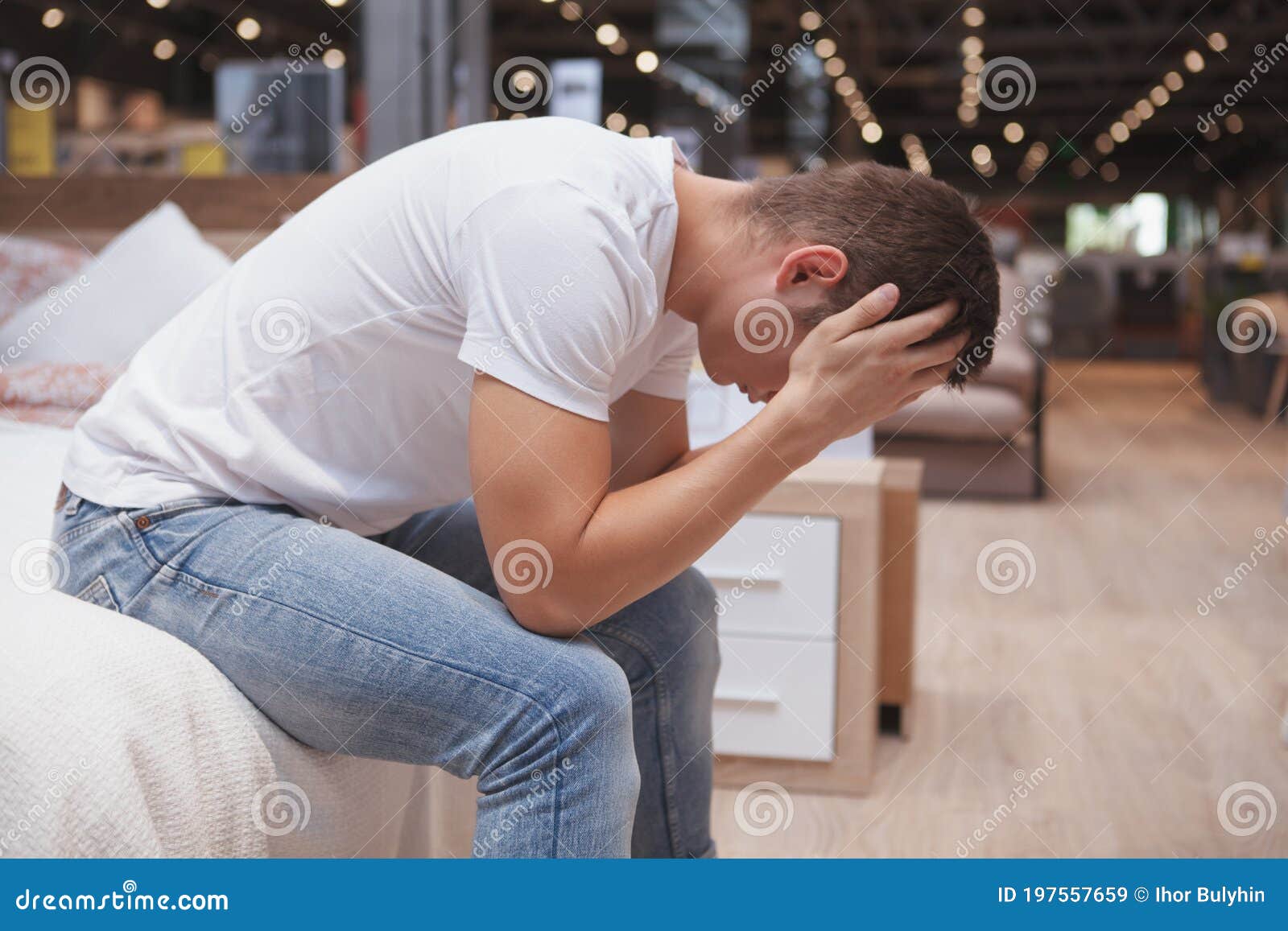 Sad man sitting on his bed stock image. Image of design - 197557659