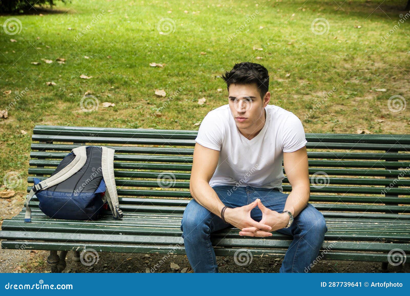 Photo of a Man Sitting on a Bench with a Backpack Stock Image - Image ...