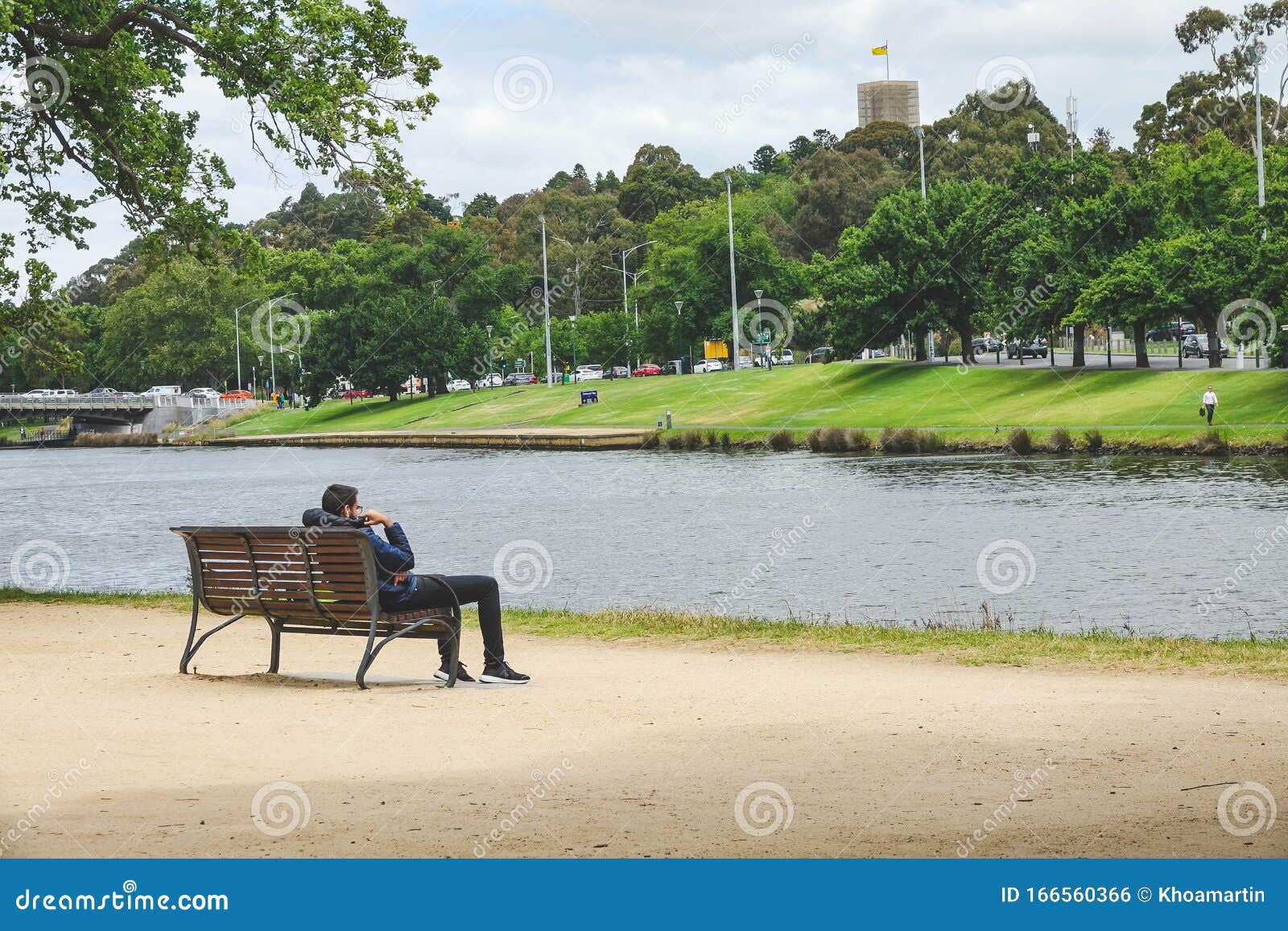 A Man Sitting on the Bench Near the River. Resting Near the Riverside ...