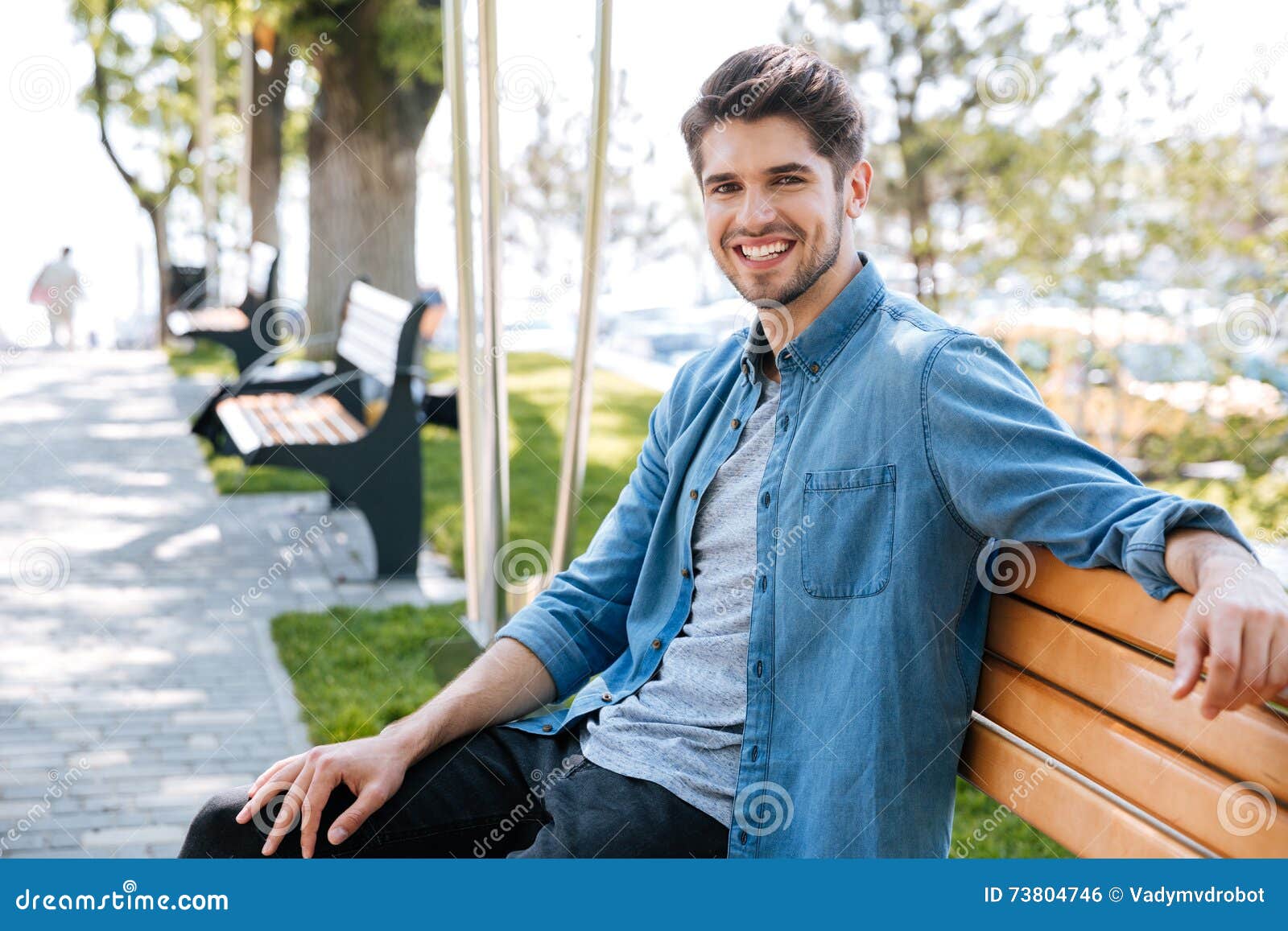 Man Sitting on a Bench Smiling Stock Photo - Image of male, happy: 73804746