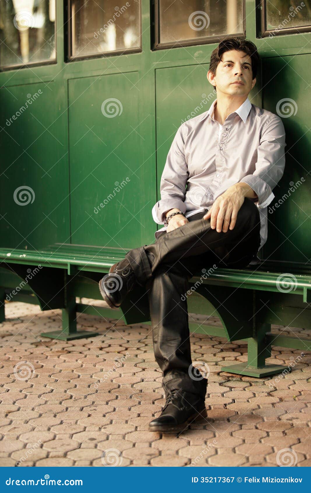 Man sitting on a bench stock image. Image of crossed - 35217367