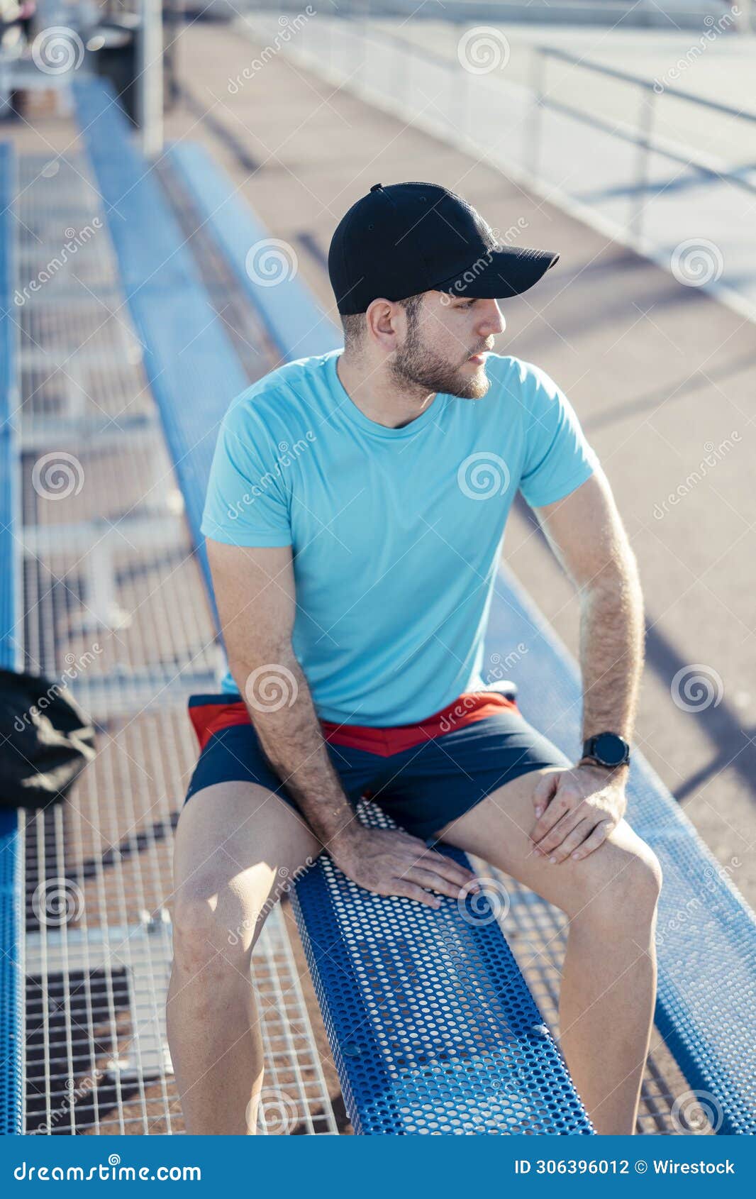 Man Sitting on a Blue Bench, Wearing a Cap Stock Photo - Image of ...