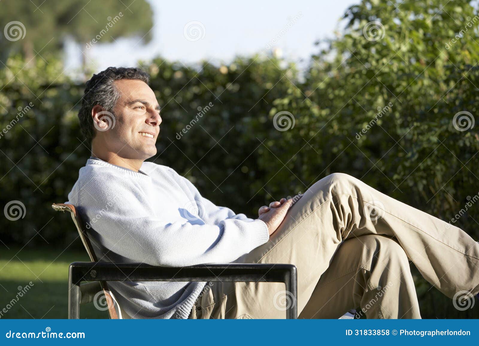 Man Sitting on Chair in Backyard Stock Photo - Image of looking, person ...