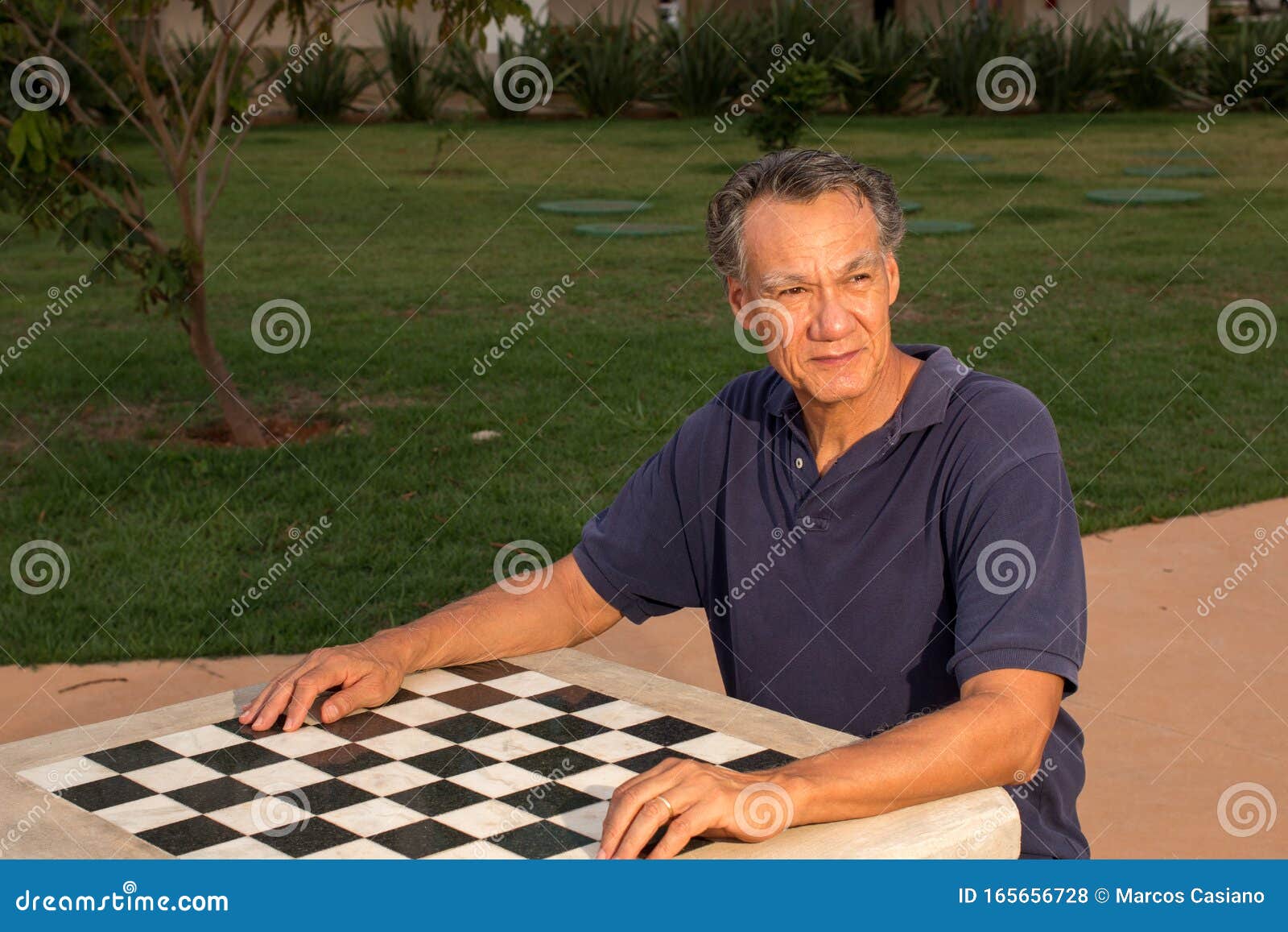 Man Sitting at a Checkerboard Table Stock Photo - Image of table ...