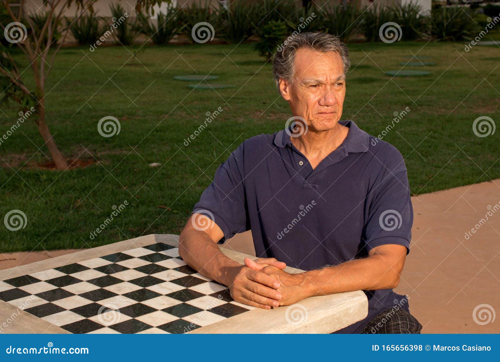 Man Sitting at a Checkerboard Table Stock Photo - Image of leisure ...
