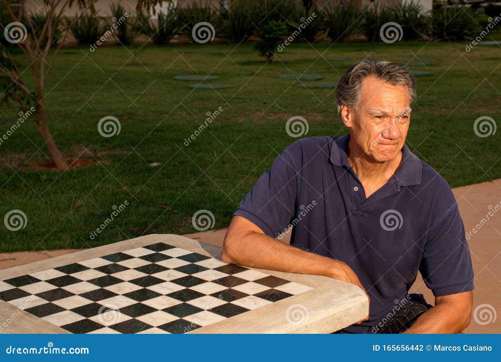 Man Sitting at a Checkerboard Table Stock Photo - Image of empty ...