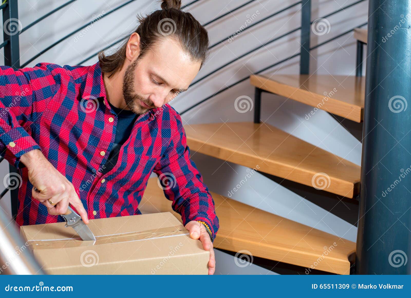Man Sitting in Corridor and Opening a Package Stock Image - Image of ...