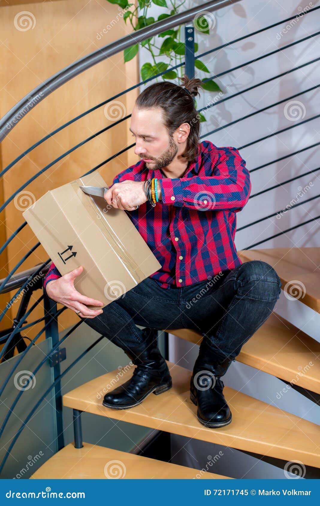 Man Sitting in Corridor and Opening a Package Stock Image - Image of ...