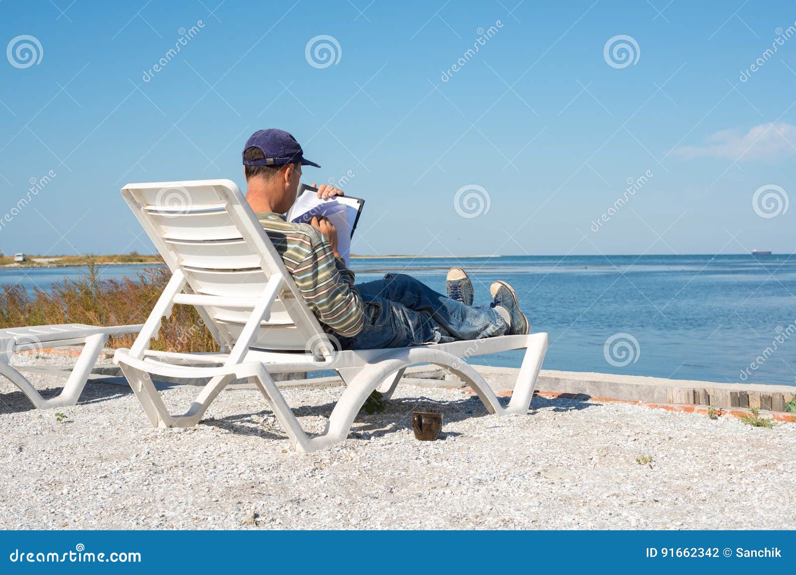 Man is Sitting on a Deckchair by the Sea, Developing the Project Stock ...
