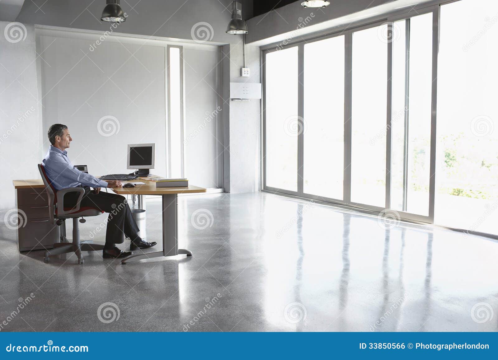 Man Sitting at Desk in Empty Office Stock Photo - Image of copyspace ...