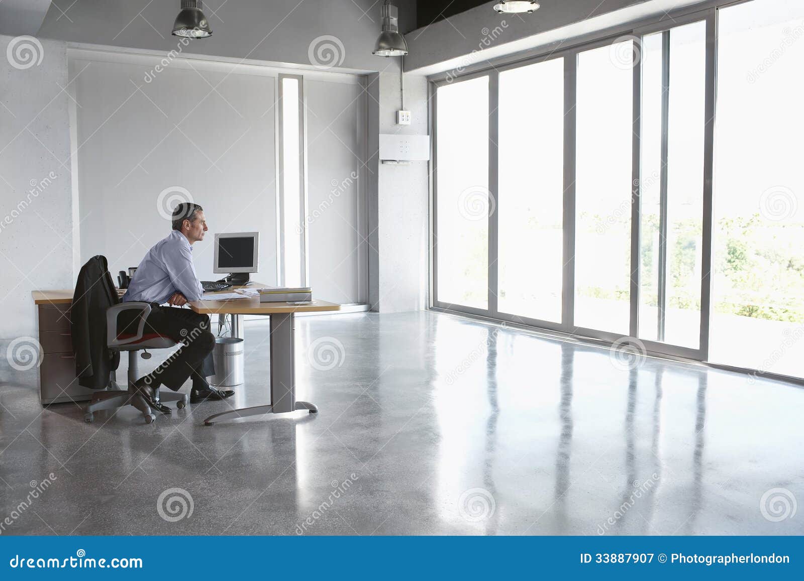 Man Sitting at Desk in Empty Office Stock Image - Image of middle ...