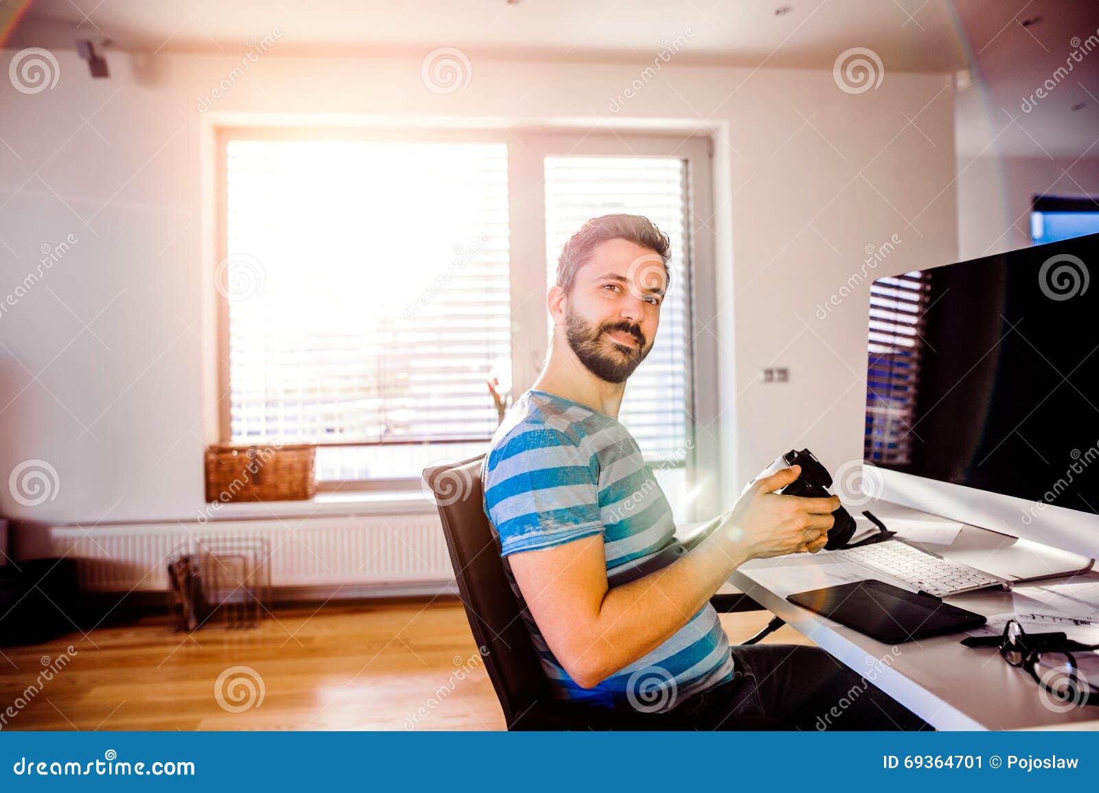 Man Sitting at Desk Working from Home Holding Camera Stock Image ...
